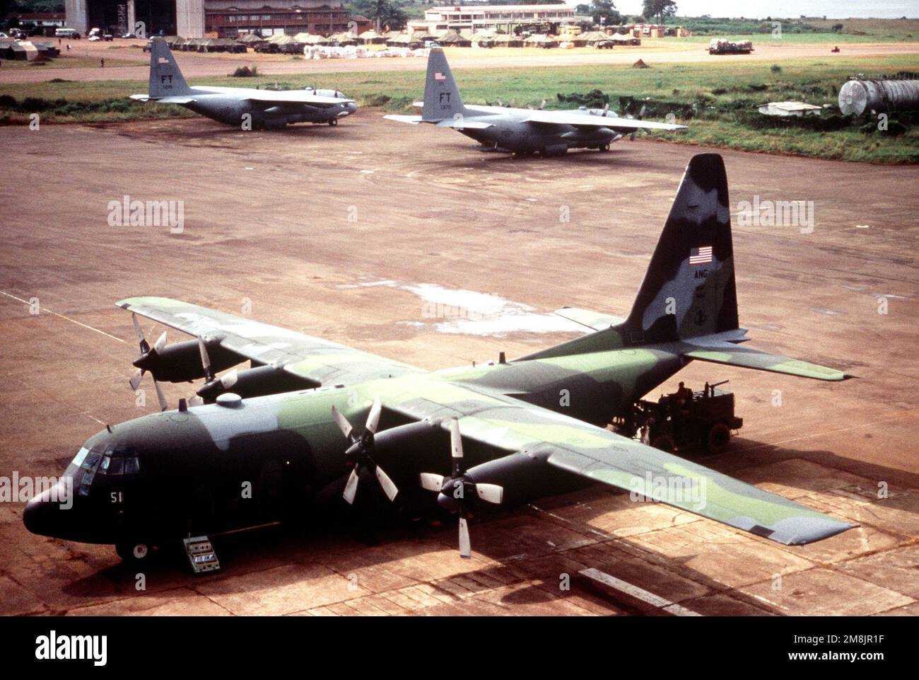 An overhead left side view of a camouflaged C-130 as it is being loaded ...