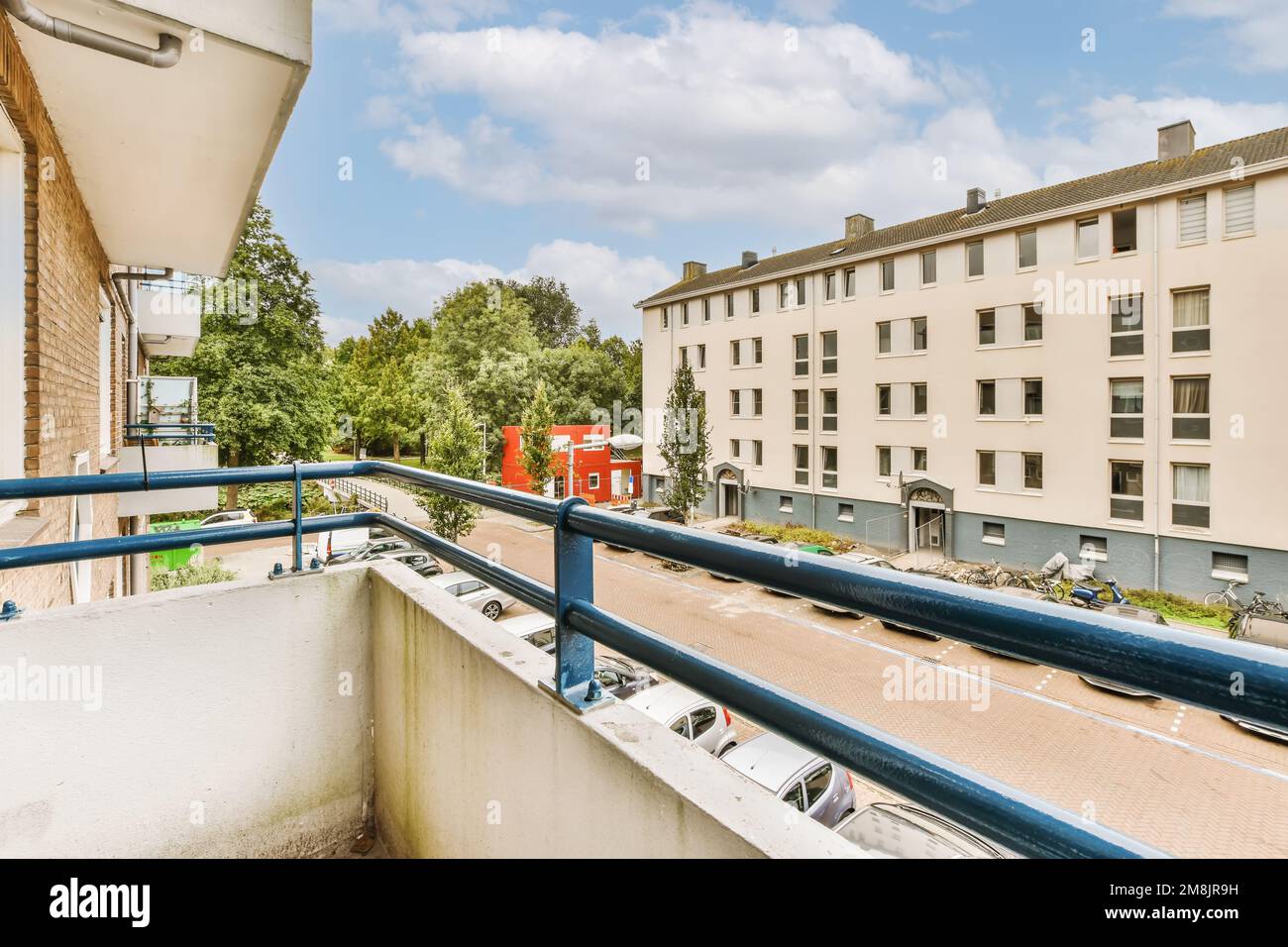 a balcony with blue railings and buildings in the background, taken ...