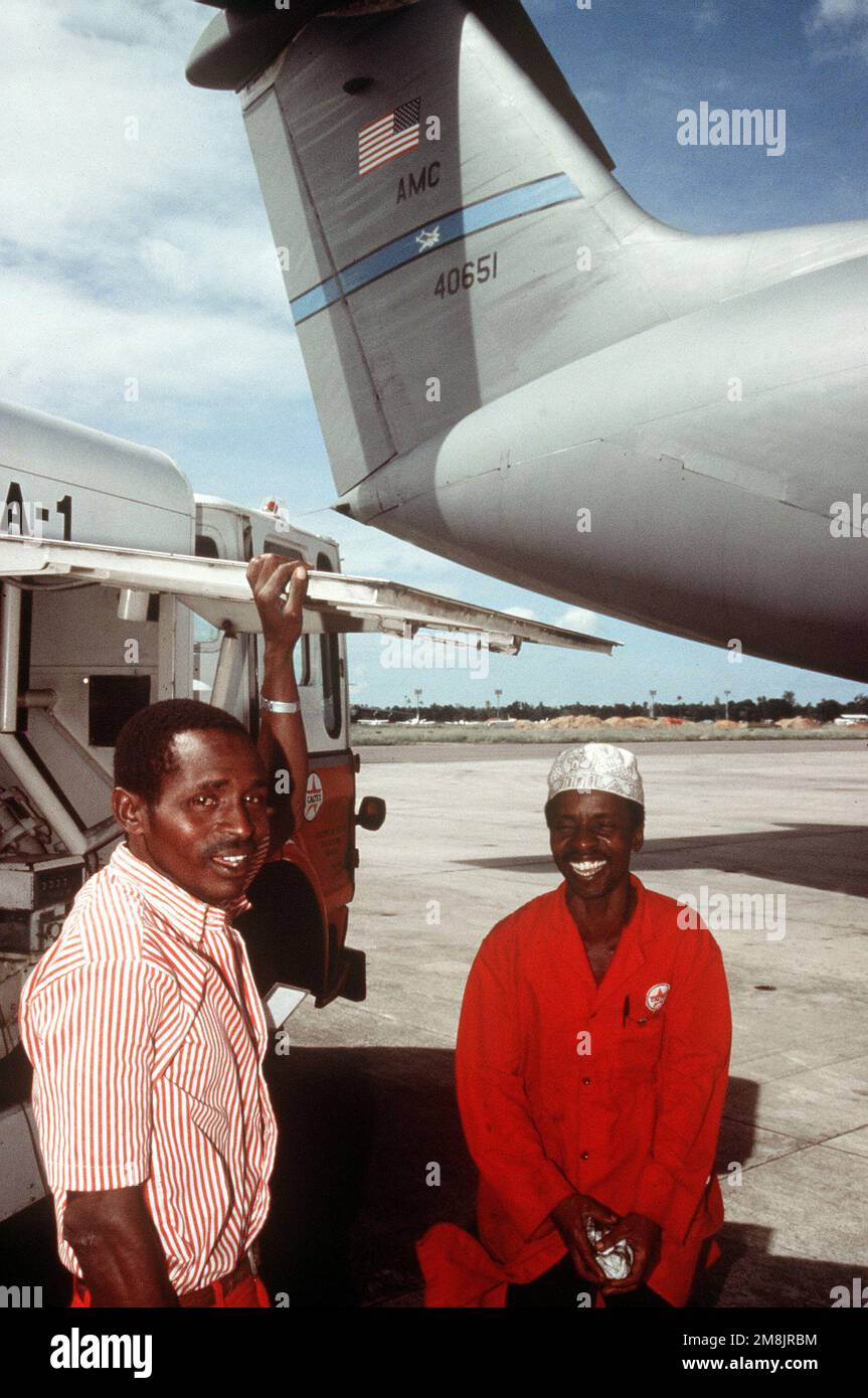 Kenyan workers take time out from pumping fuel to smile for the camera ...