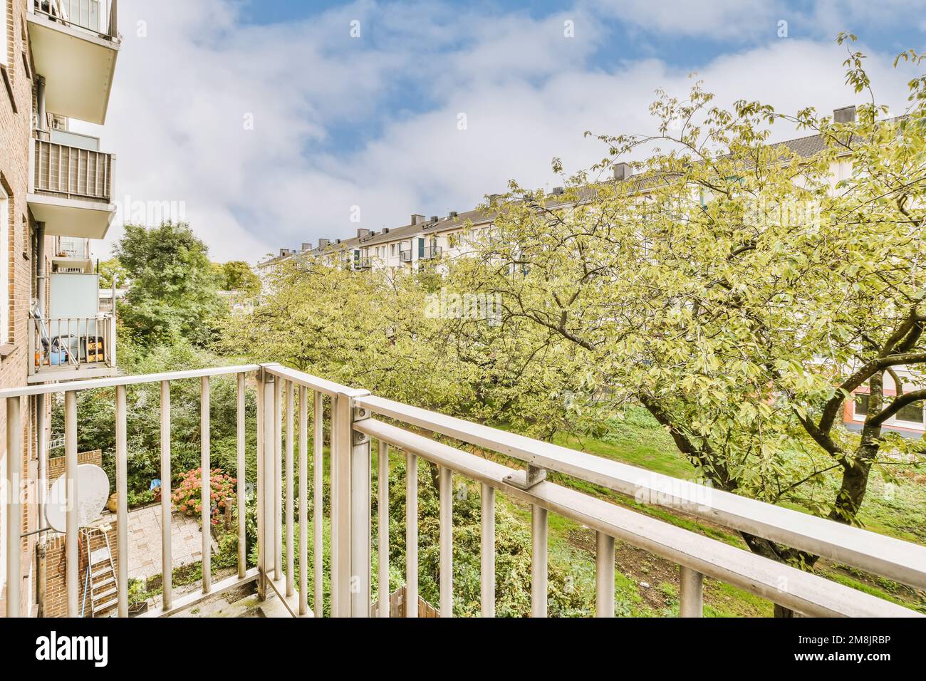an apartment balcony with white railings and green trees in the ...