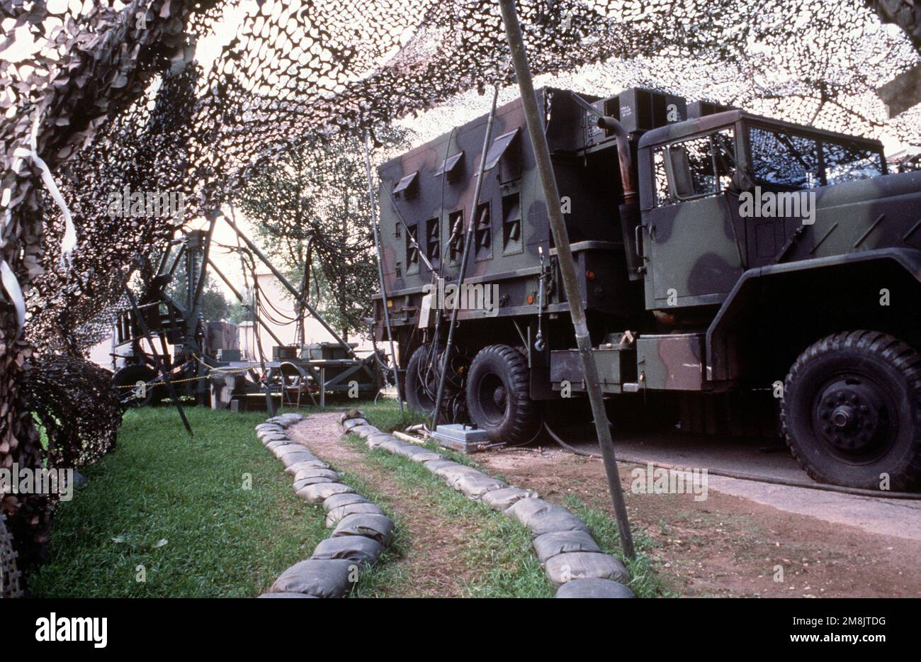 Back up generators sit ready for use under camouflage netting. Subject ...