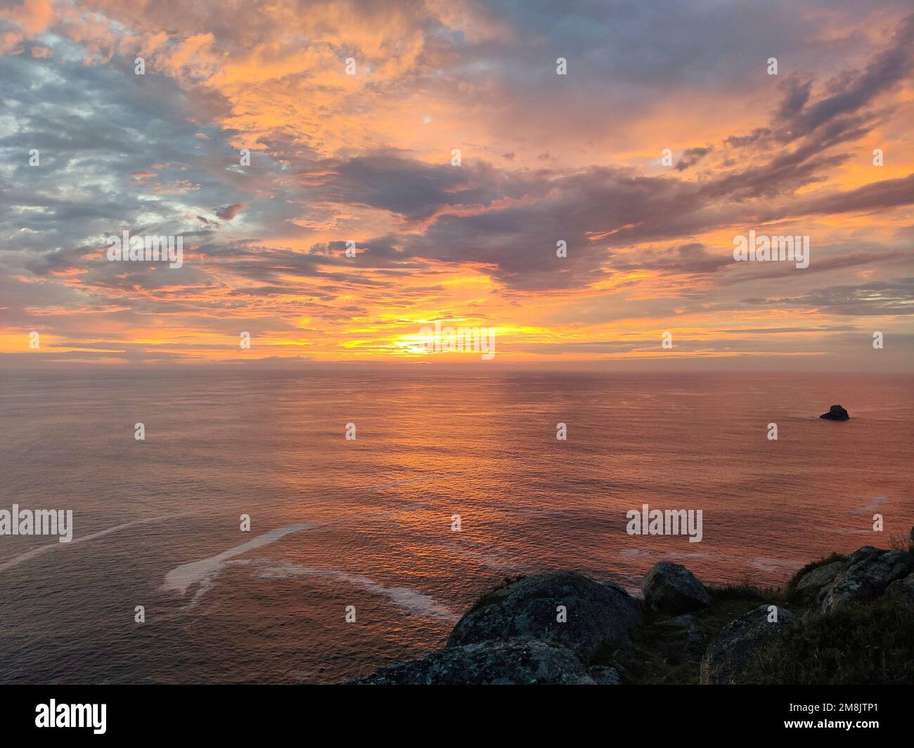 sunset in finisterre, the last place of the world Stock Photo - Alamy