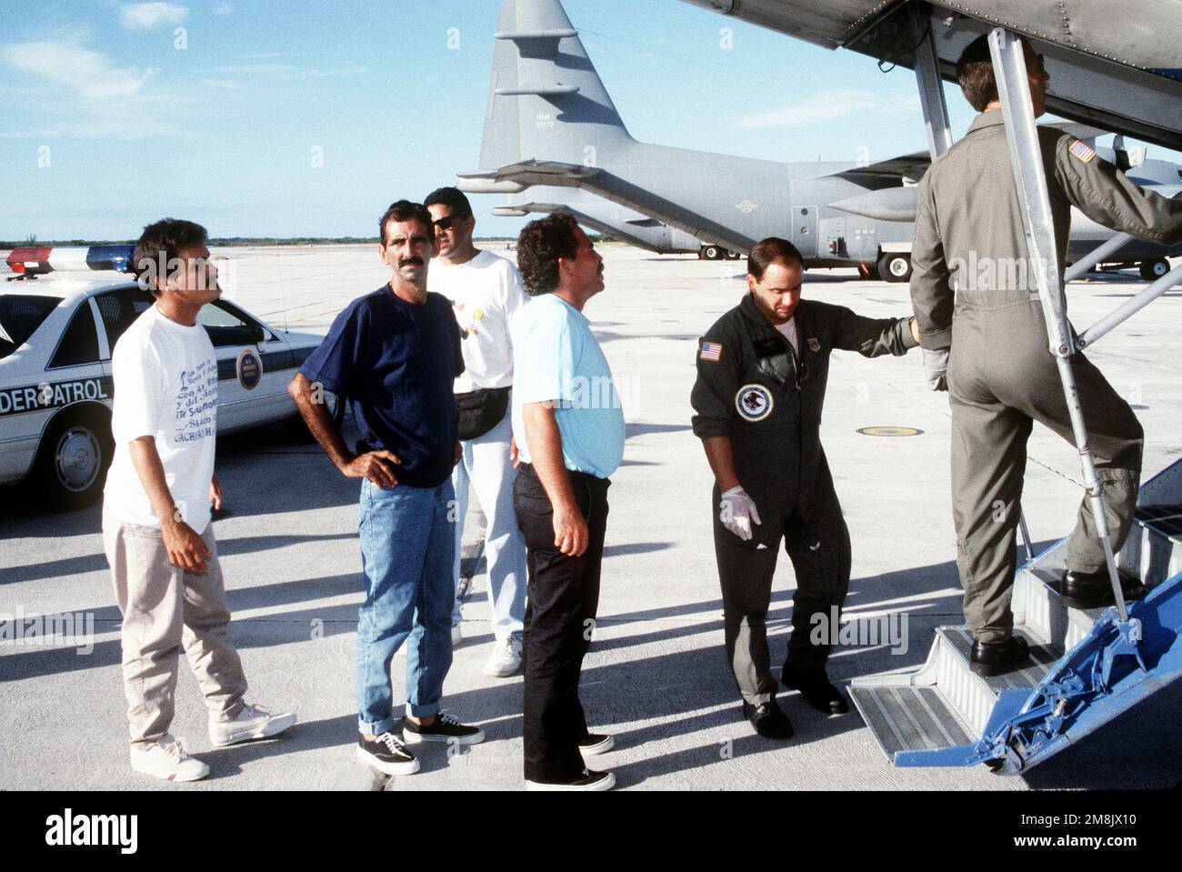 Cuban migrants are shown boarding a C-9 aircraft for transportation ...