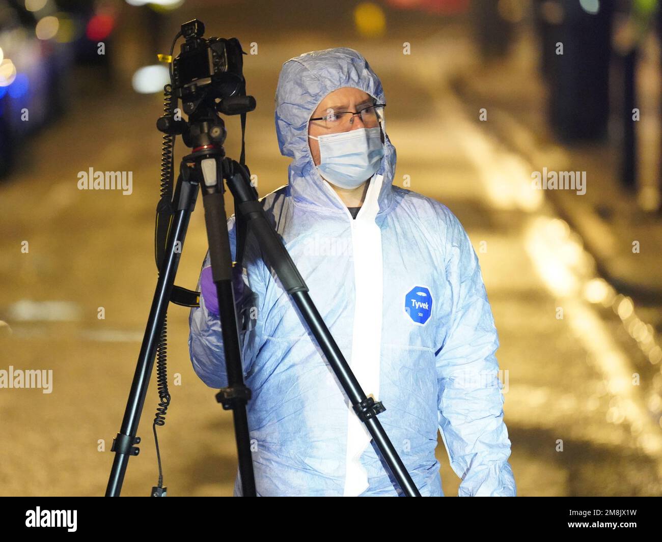 A police forensic officer works near to the scene of a suspected drive ...