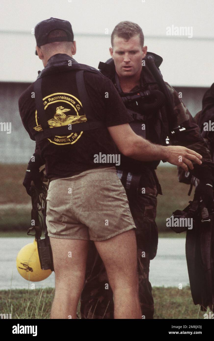 Lance CPL. Smith is assisted by CAPT. Liberto in making his dive suit ...
