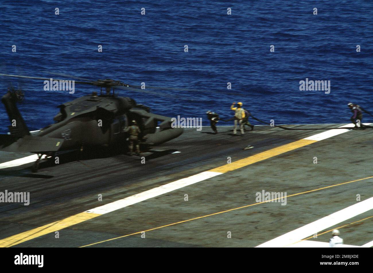 Crew members stand by to refuel a US Army UH-60 Black Hawk (Blackhawk ...