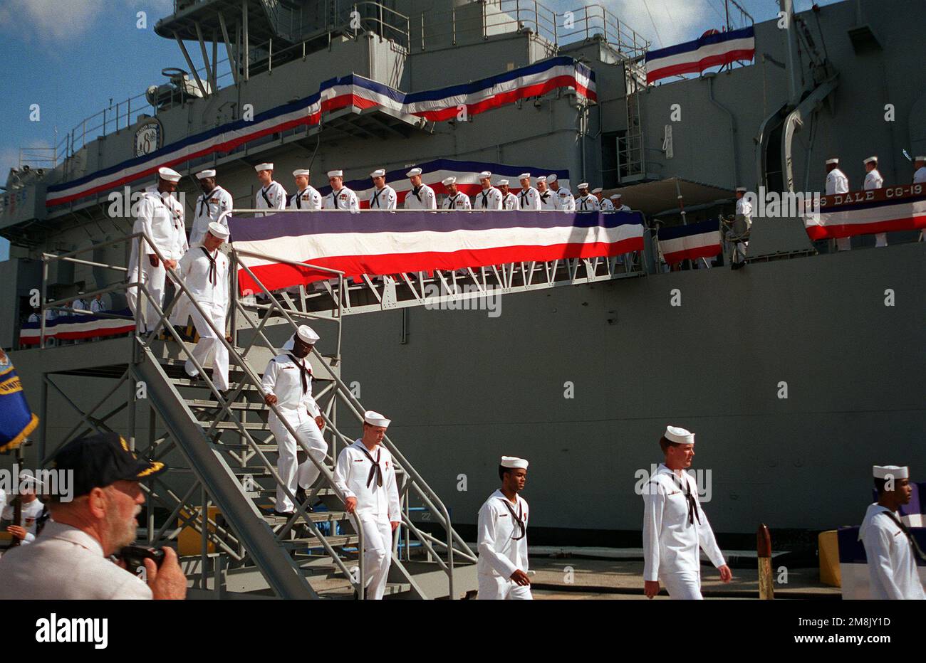 Crew members of the guided missile cruiser USS DALE (CG-19) file down ...