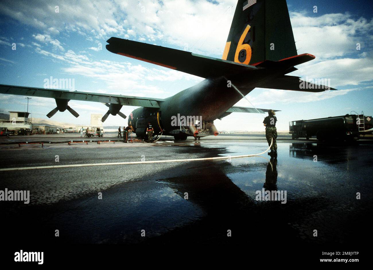 Pit crews wash retardant off a C-130 Hercules of the 115th Airlift ...