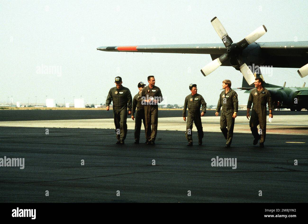 Pilots and crew walk across the flightline as they take a much needed ...