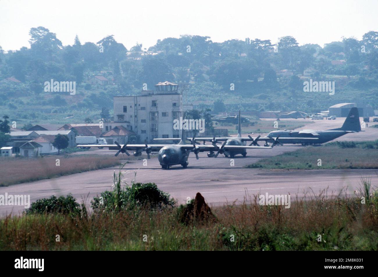 Three USAF C-130 Hercules aircraft are parked in front of the empty ...