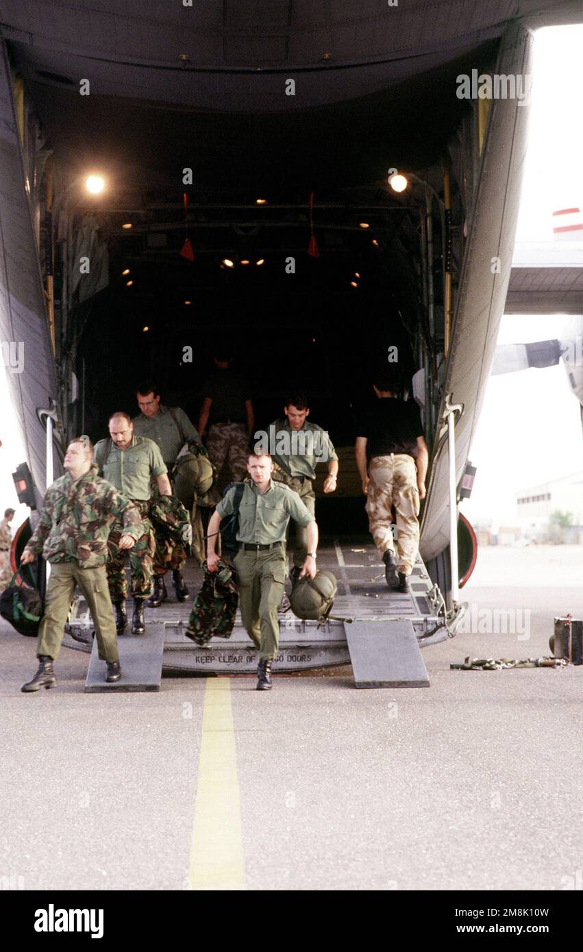 British troops depart a British C-130 after its arrival at Kuwait ...