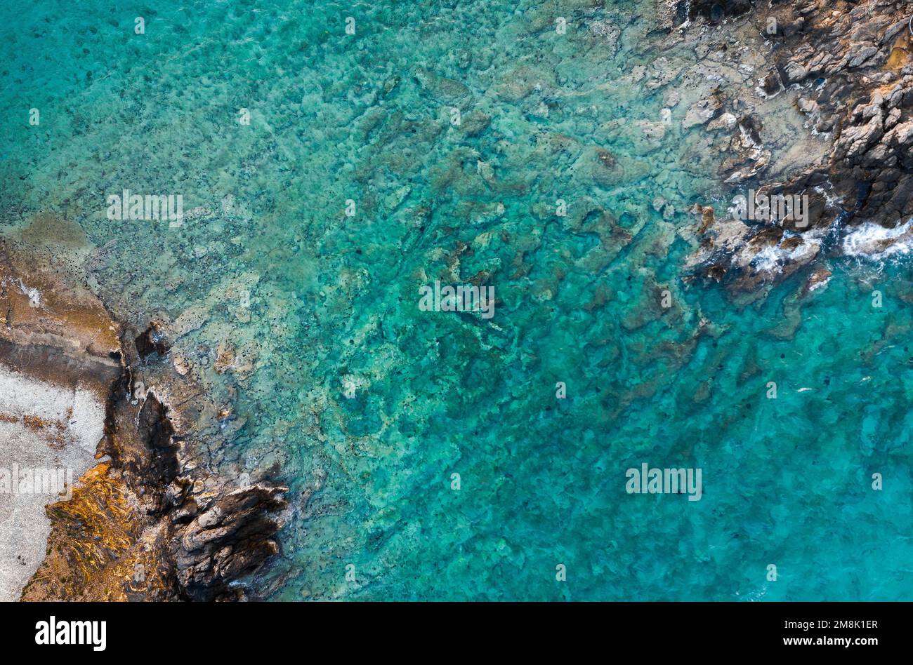 A bird's eye view of the clear water of the sea with rocks Stock Photo ...