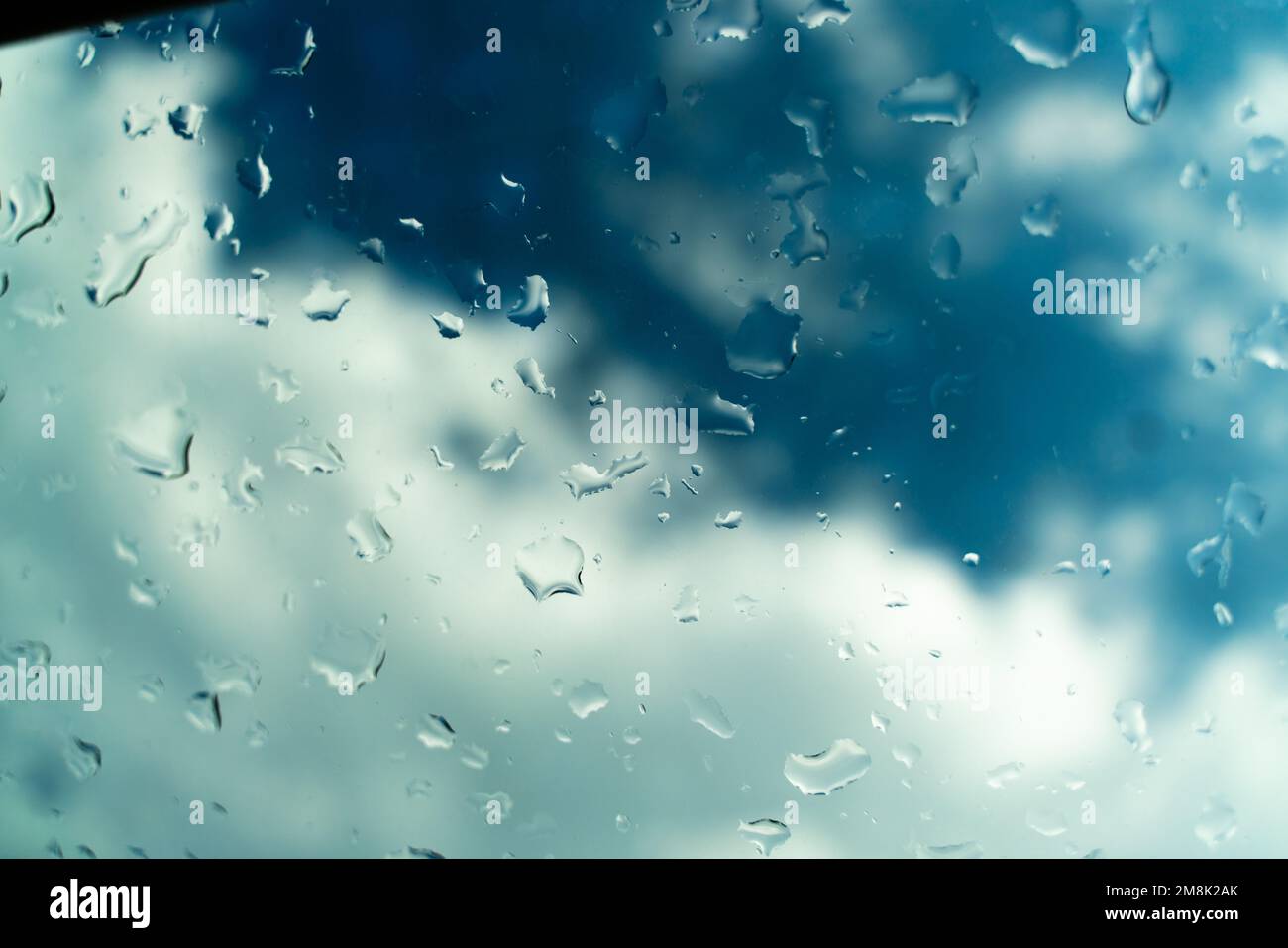 Water drops on glass against blue sky. Window view background ...
