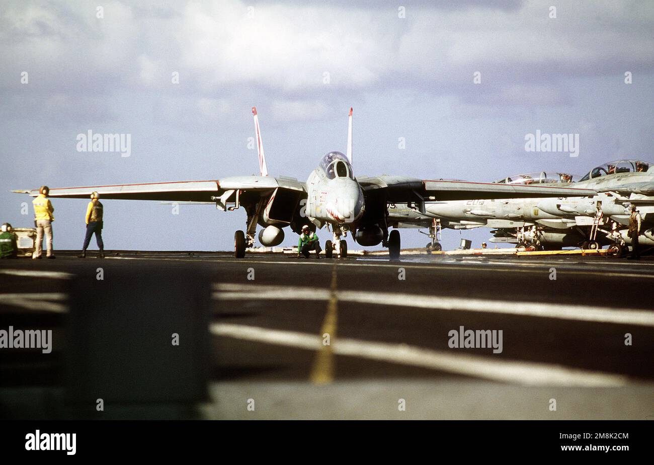 A US Navy F-14 Tomcat is hooked up to the catapult for launch from the ...