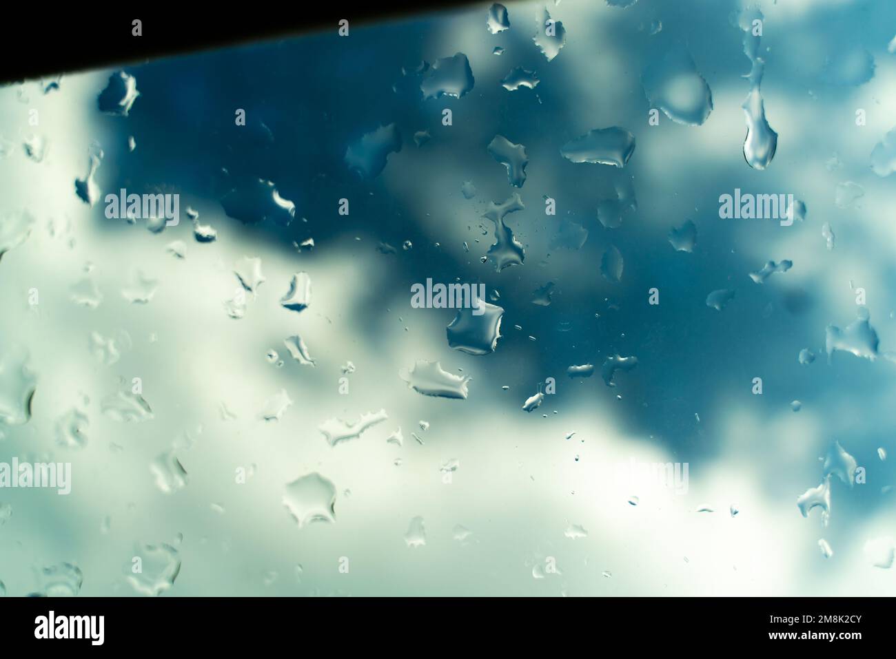 Water drops on glass against blue sky, rainy season concept. Window ...