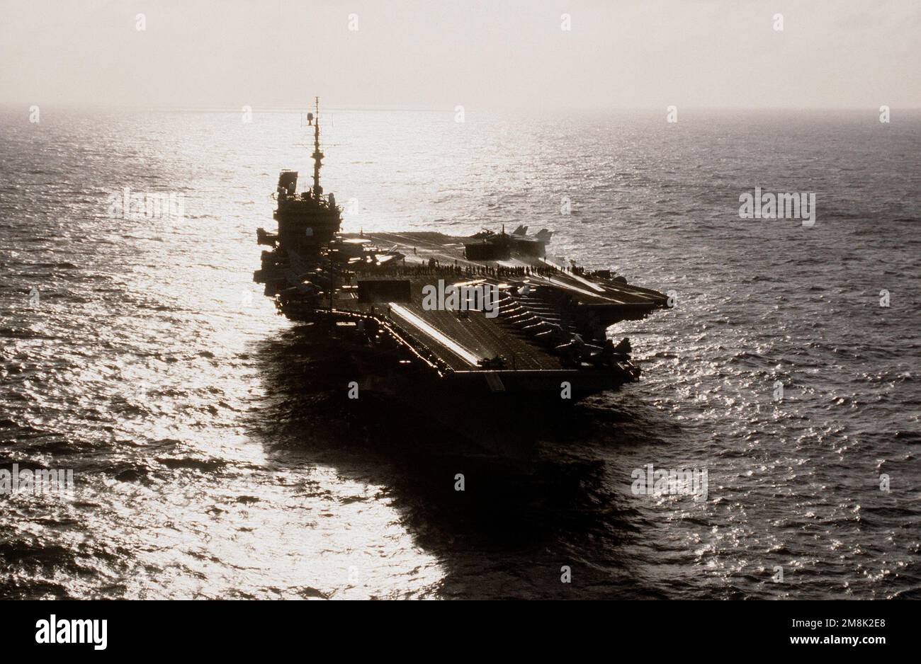 The flight deck crew of USS KITTY HAWK (CV-63) lines up and walks down ...