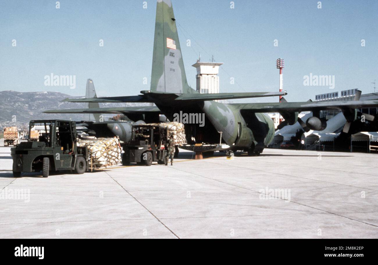 USAF personnel use forklifts to unload pallets of cargo from an Air ...