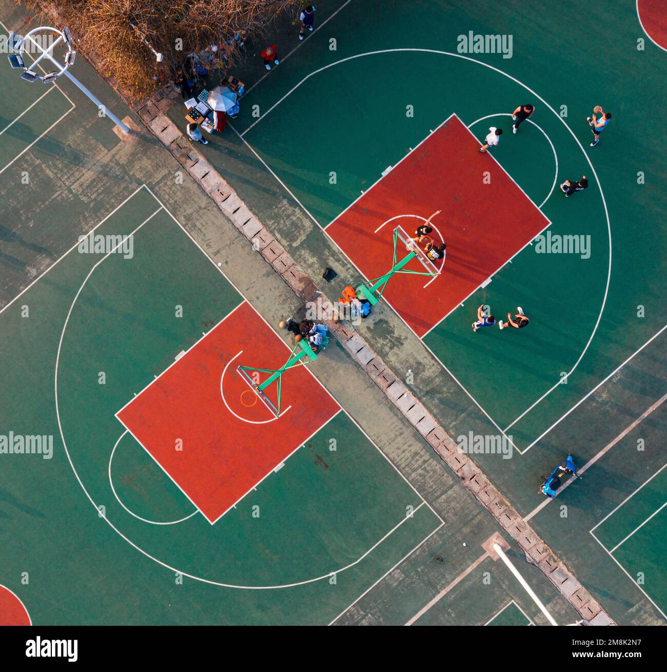 An aerial top view of two seperate basketball courts and young people ...