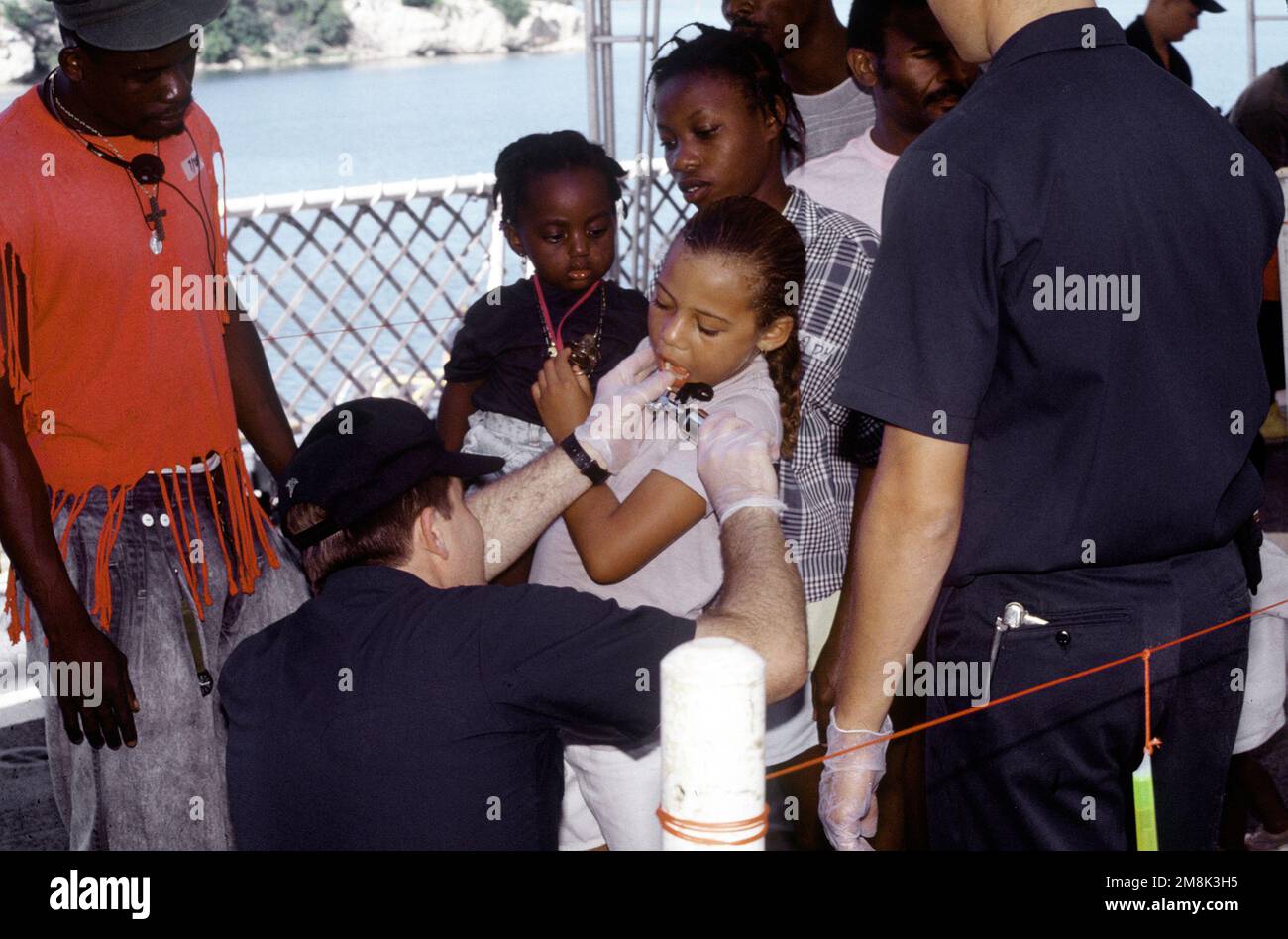 A Haitian repatriate is given a brief medical exam onboard the US Coast ...