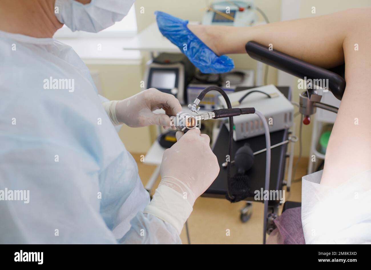 a male doctor in a white coat and rubber gloves, holding a colonoscope ...