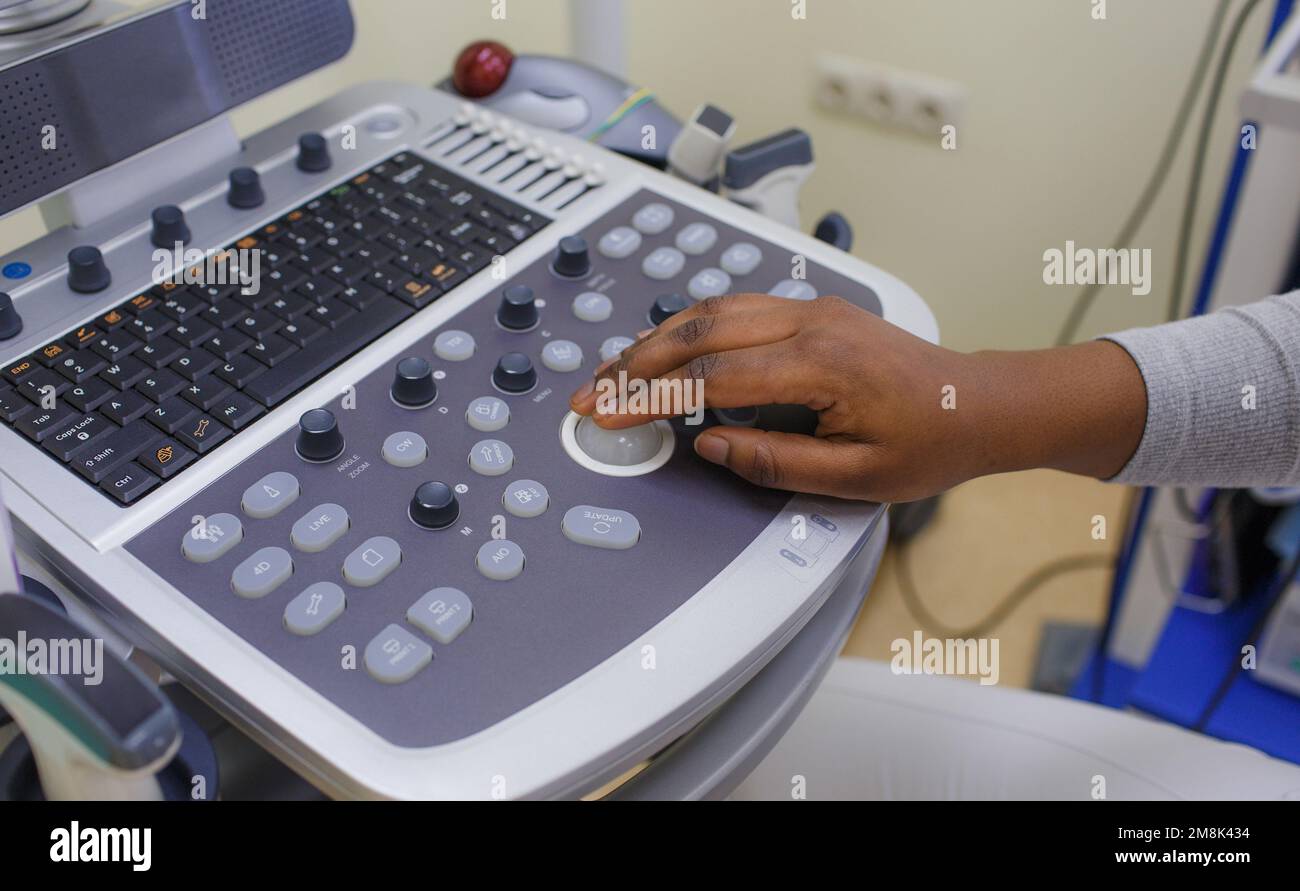 The hand of an African doctor lies on the control panel of an ...