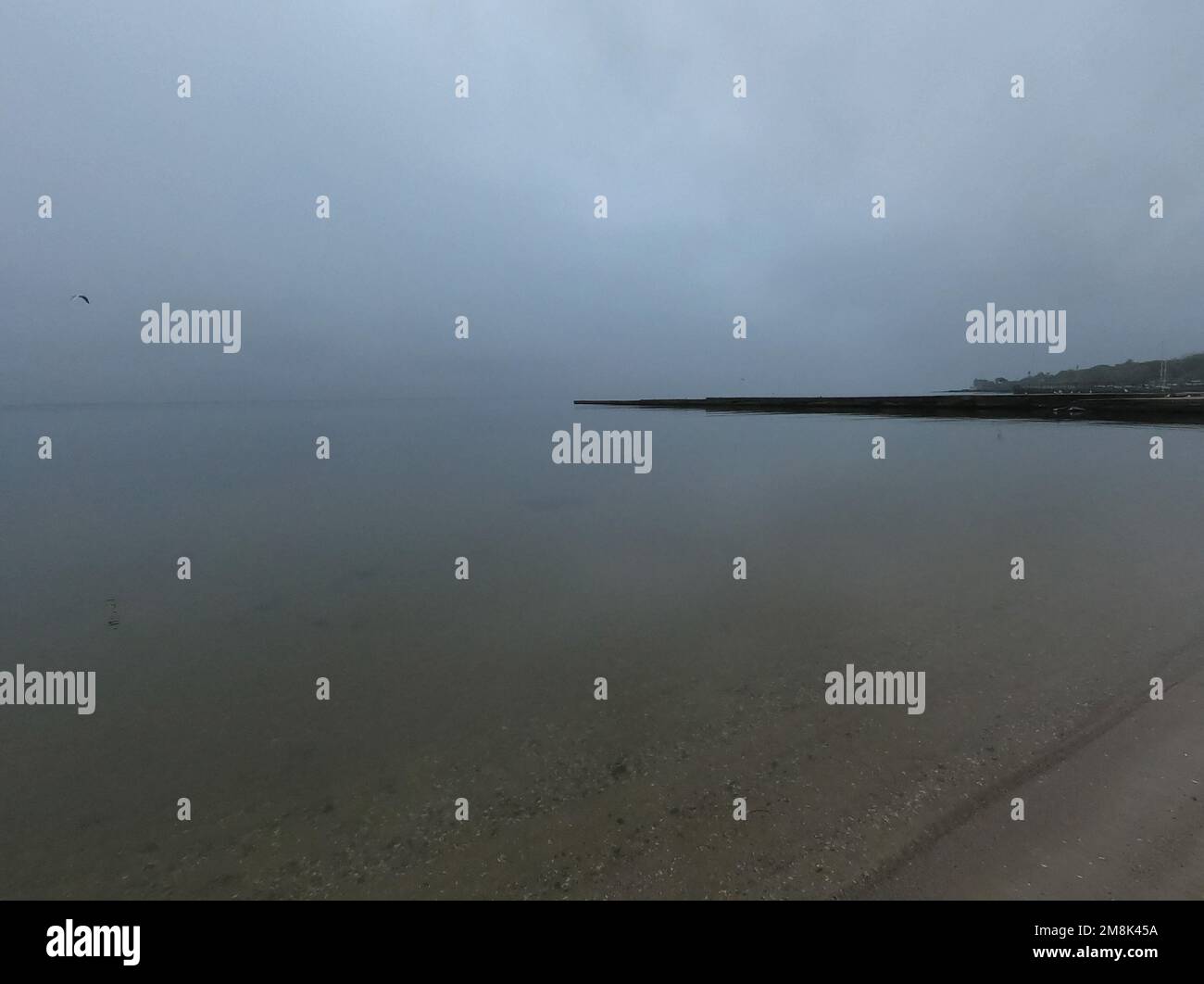 Sandy beach on calm sea. Calm sea cloudy weather. Smooth waveless sea ...