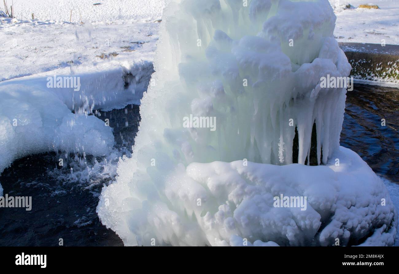 Iced fountain in the park on a winter sunny day. Fountain with frozen ...