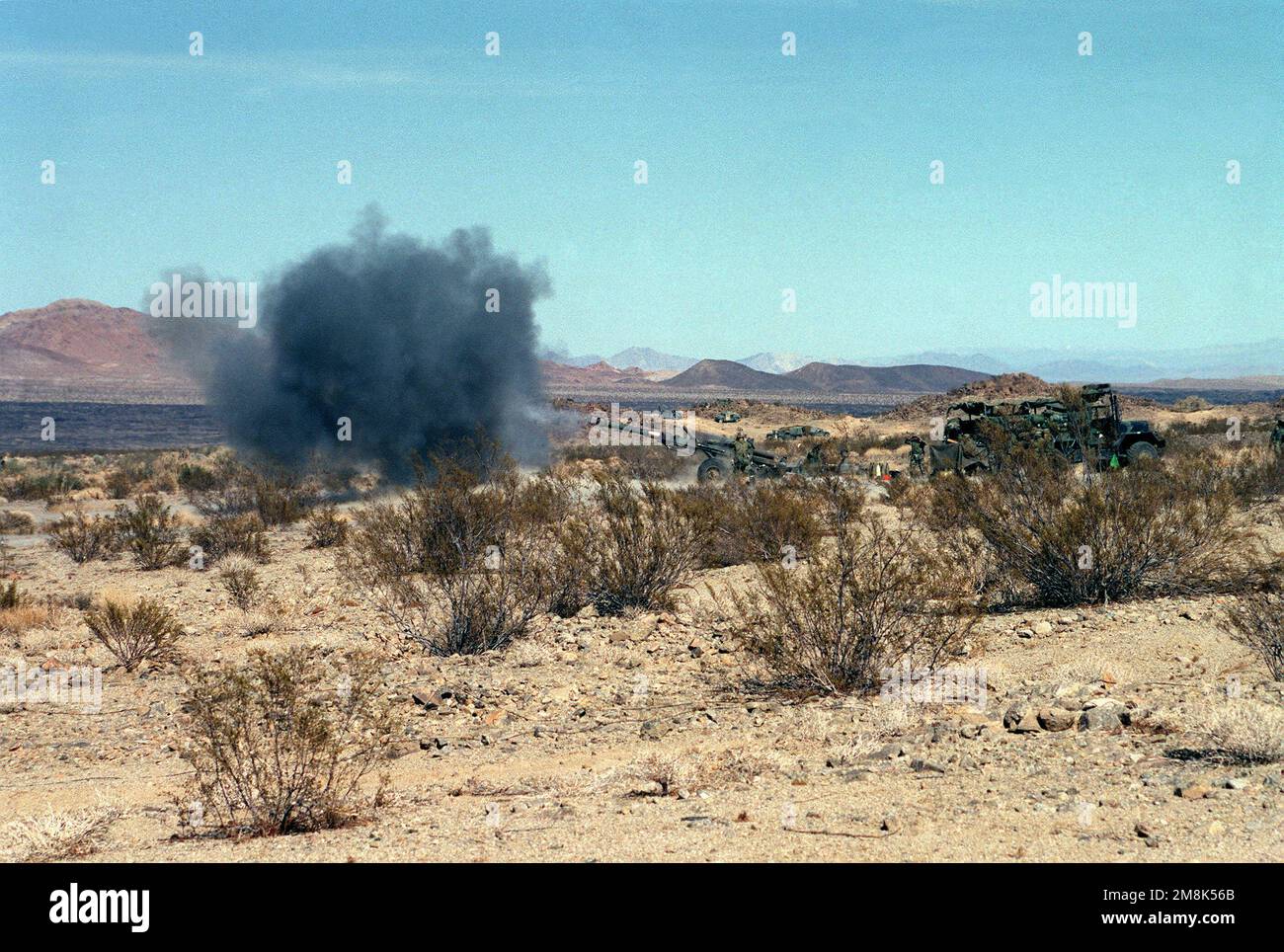 Long shot, left side view, M198 155mm Howitzer cloud of smoke in front ...