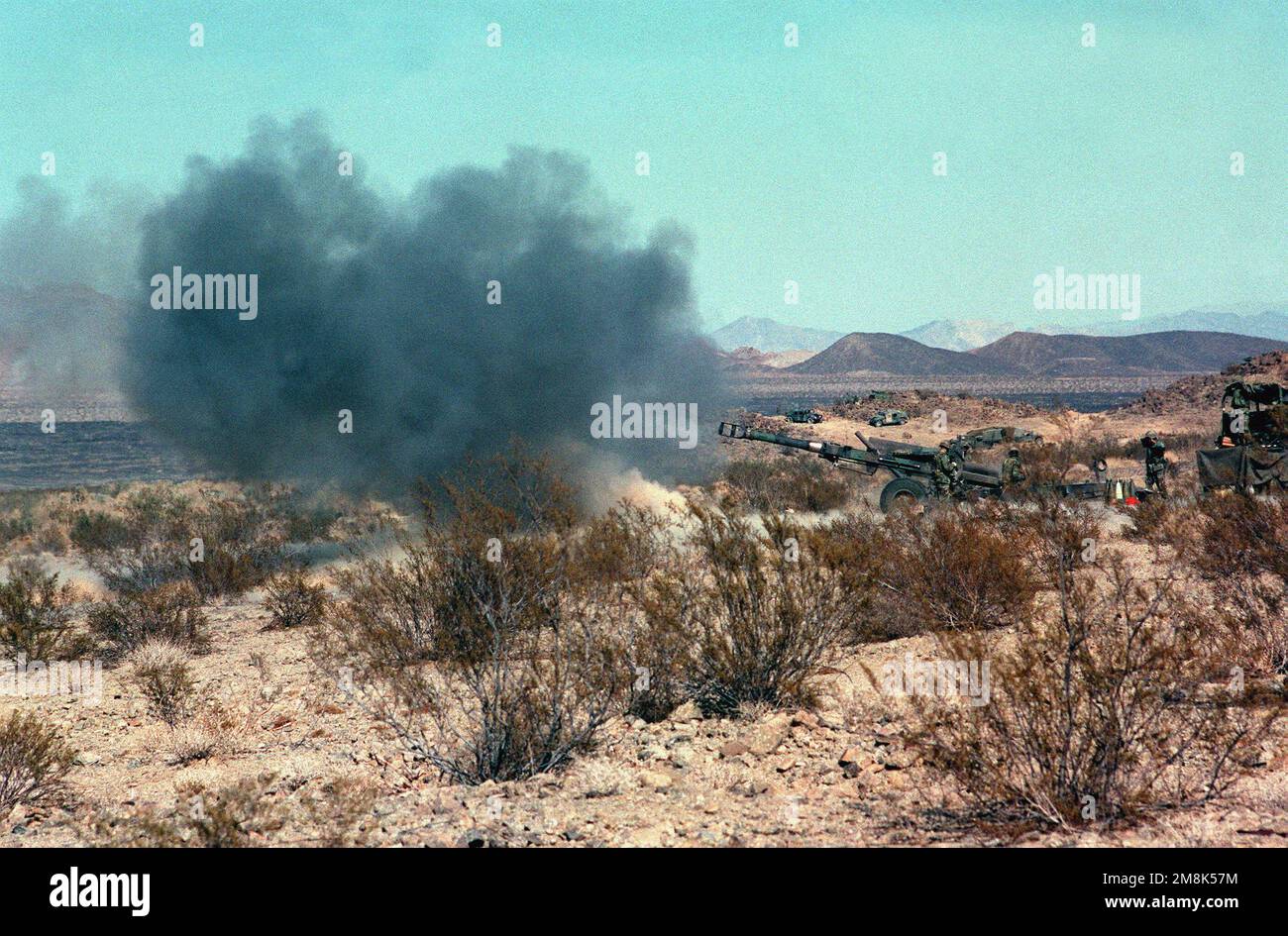 Long shot, left side view, M198 155mm Howitzer cloud of smoke in front ...