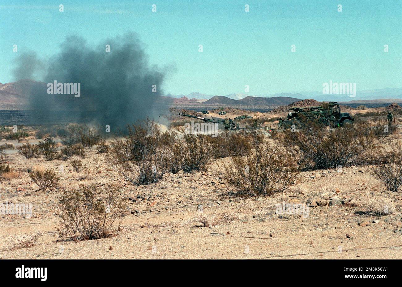 Long shot, left side view, M198 155mm Howitzer cloud of smoke in front ...