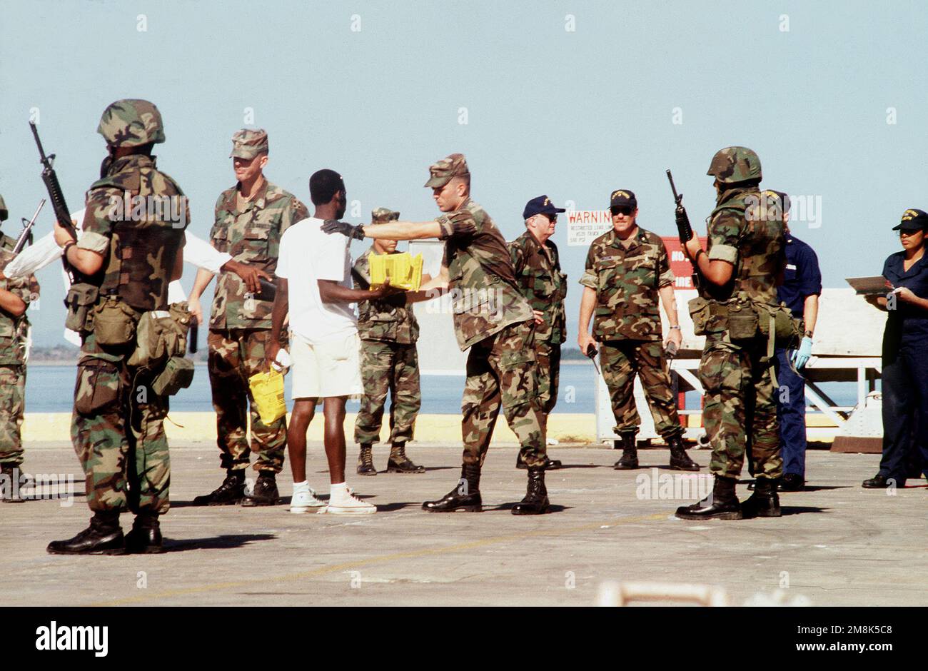 Haitian non-voluntary repatriates are screened before boarding the U.S ...