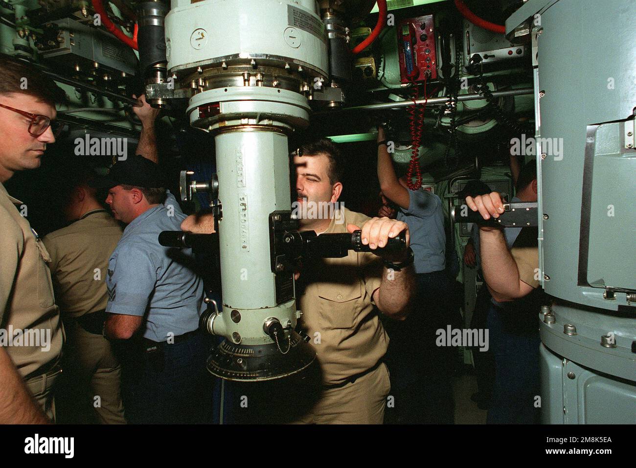 A chief petty officer looks into the number one attack periscope on ...