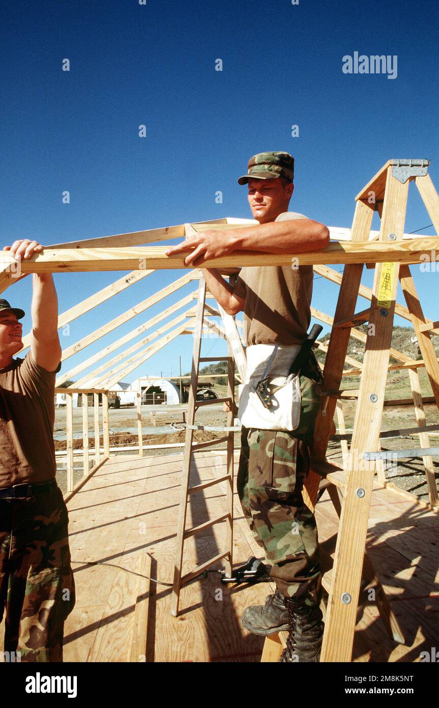 U.S. Army soldiers construct a frame for a hardback tent for use by ...