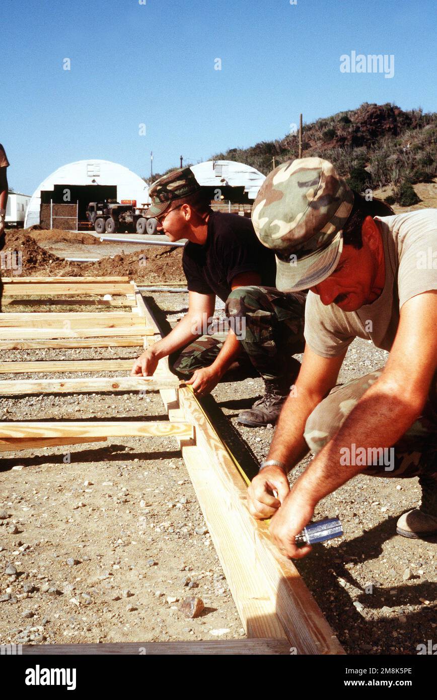 U.S. Army soldiers construct a frame for a hardback tent for use by ...