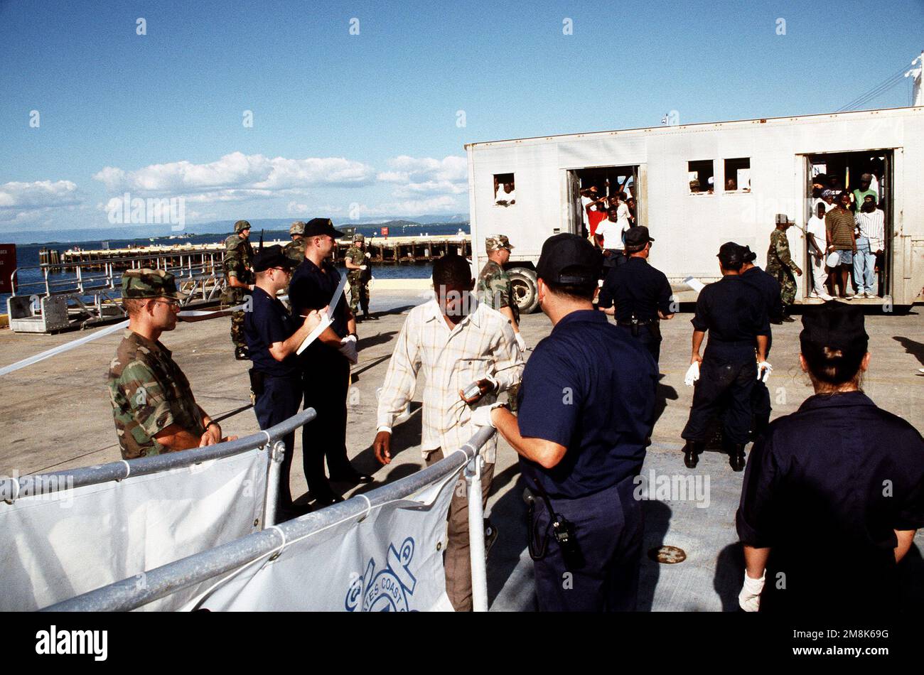 A voluntary Haitian repatriate passes a security team and approaches ...
