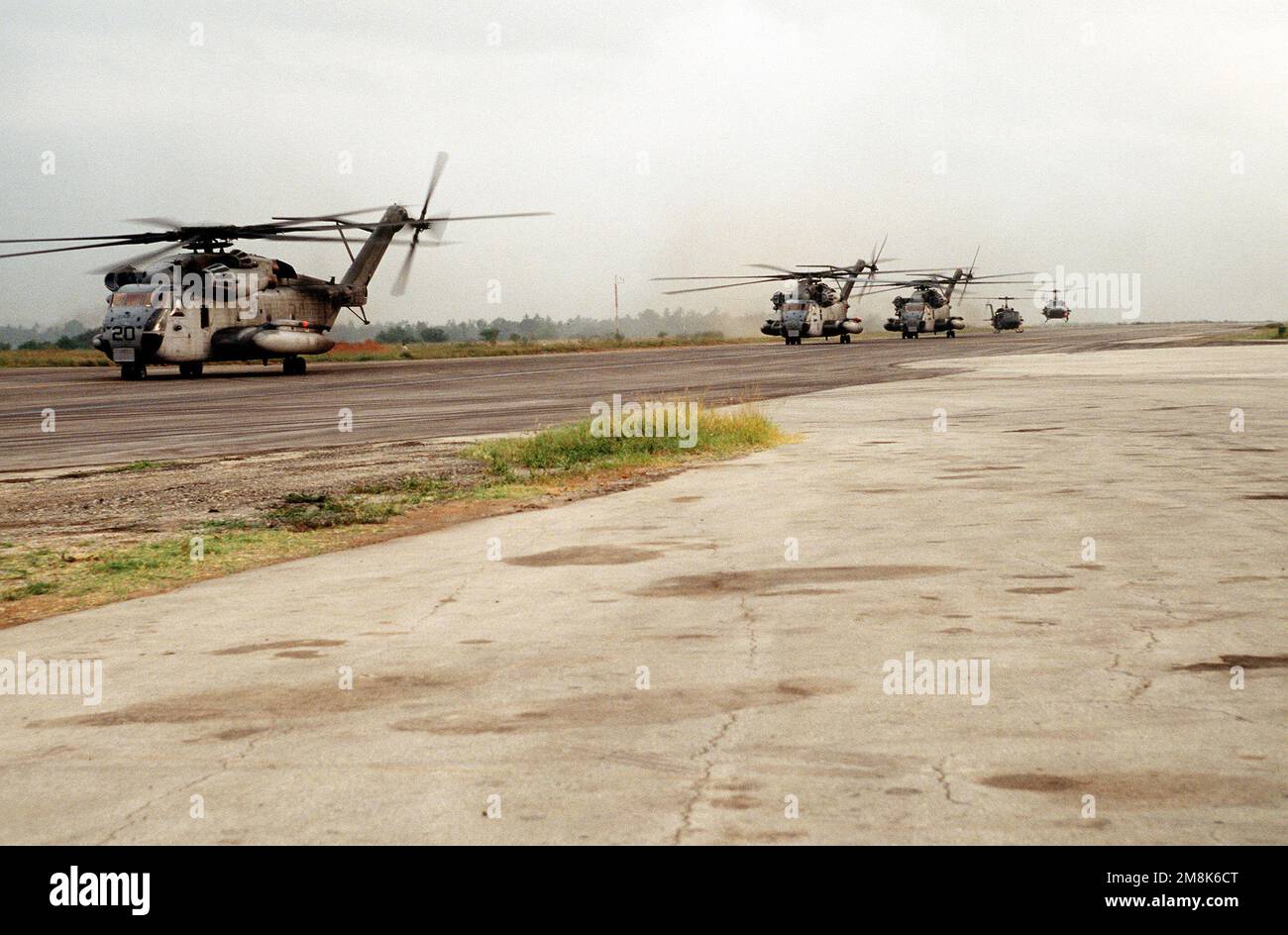 US Marine Corps CH-53 Sea Stallion and UH-1 Huey helicopters taxi to a ...
