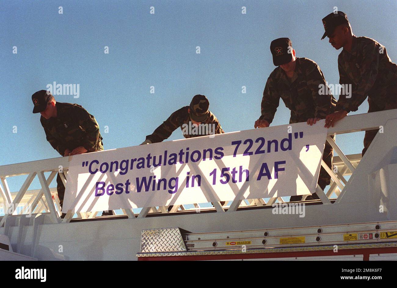 AIRMAN hang a banner on the fire truck congratulating the 722 ARW for ...