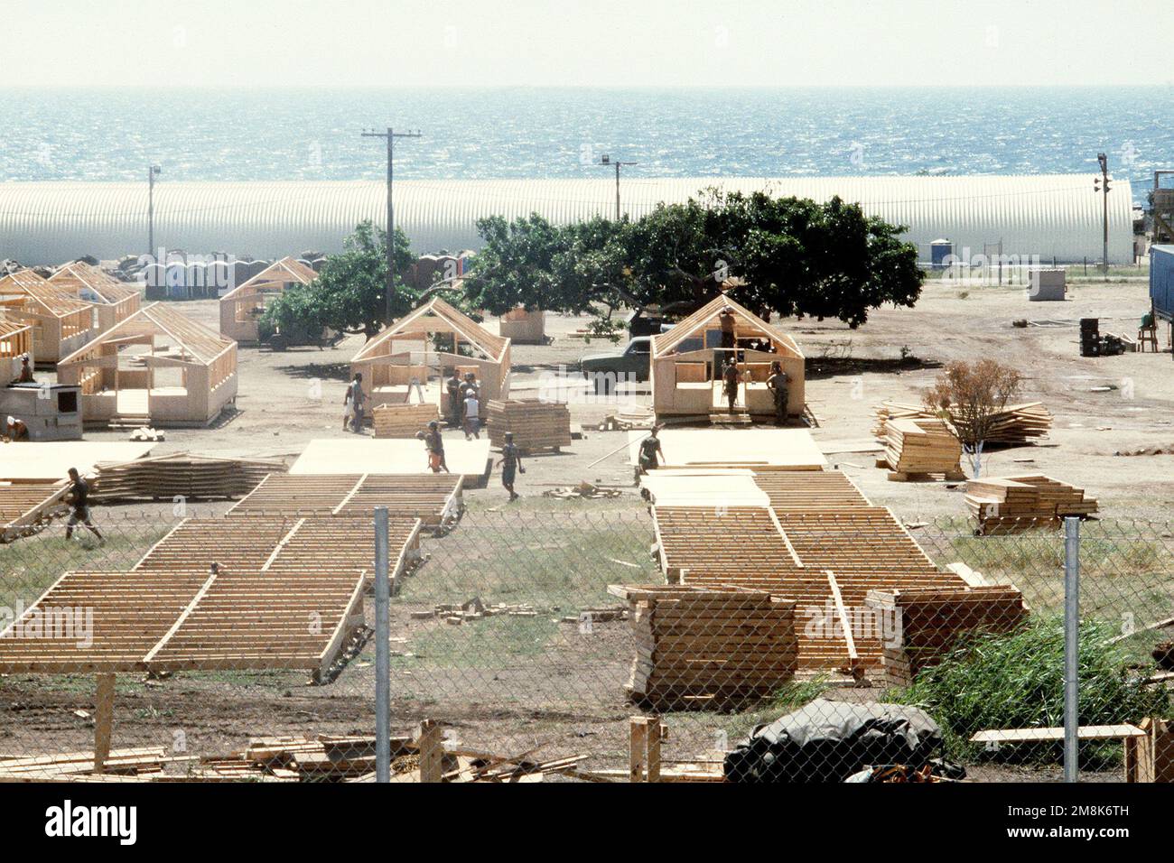 U.S. Navy Seabees work with Cuban migrants in building rows of hardback ...