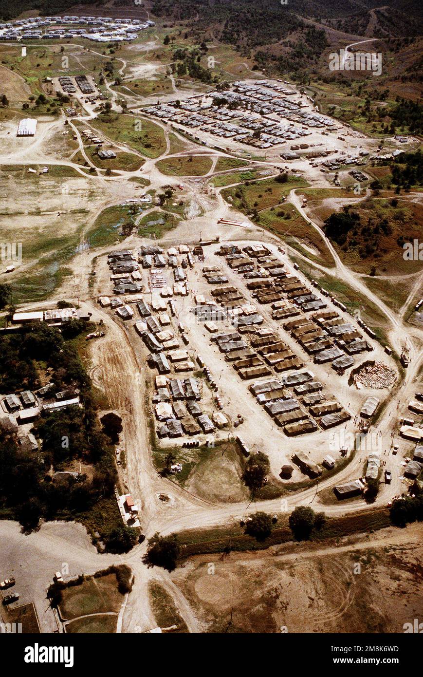 An aerial view of the migrant camps built on the rifle range. Subject ...