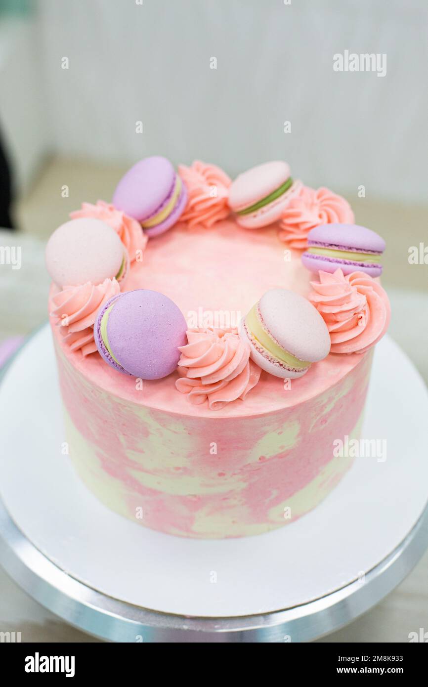 pink cake decorated with melted white chocolate, macaroons Stock Photo ...