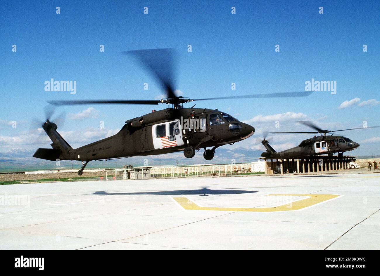 Two US Army UH-60 Black Hawk (Blackhawk) helicopters land at the ...