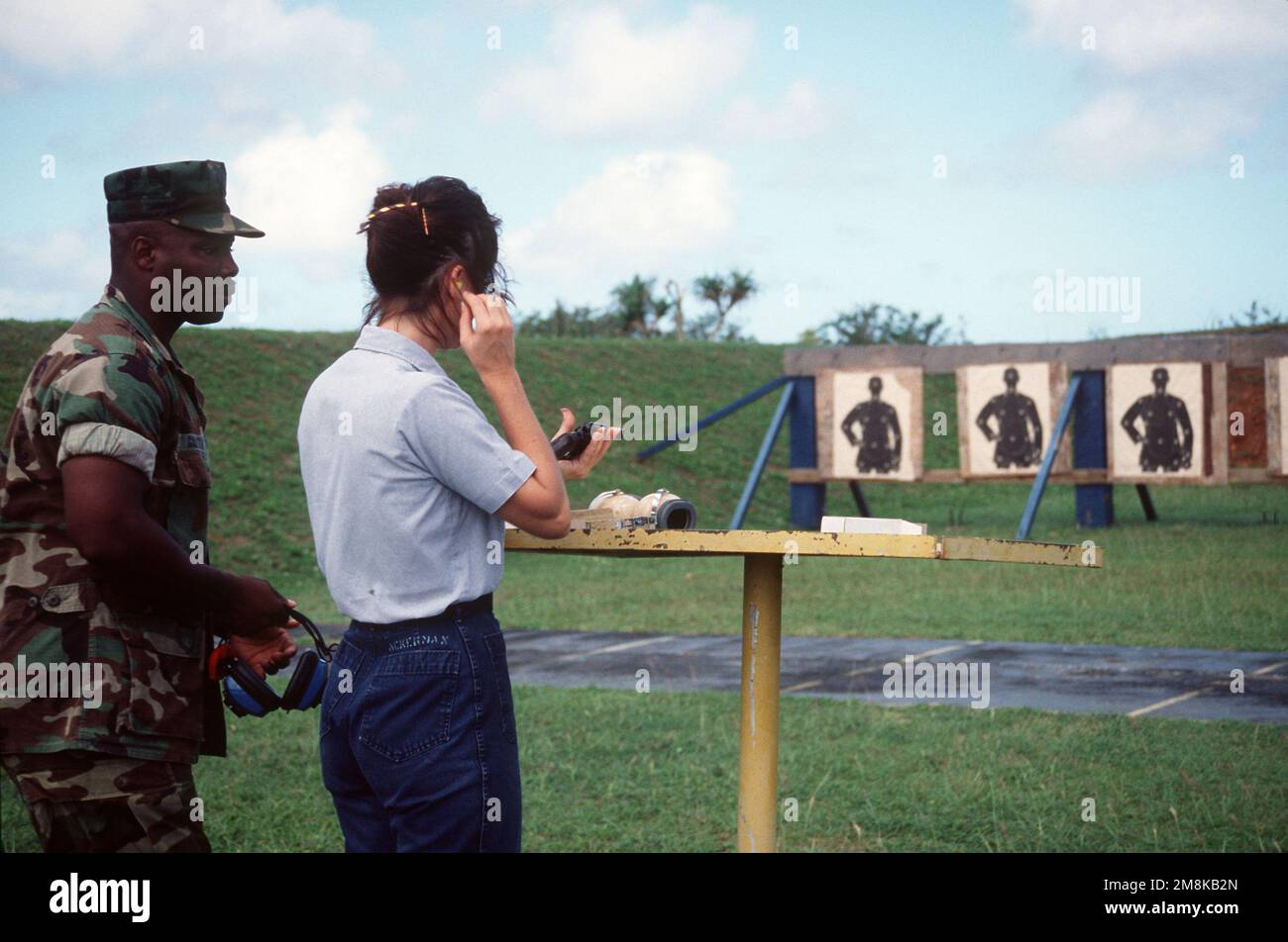 A range safety officer instructs Photographer's Mate Second Class (PH2 ...
