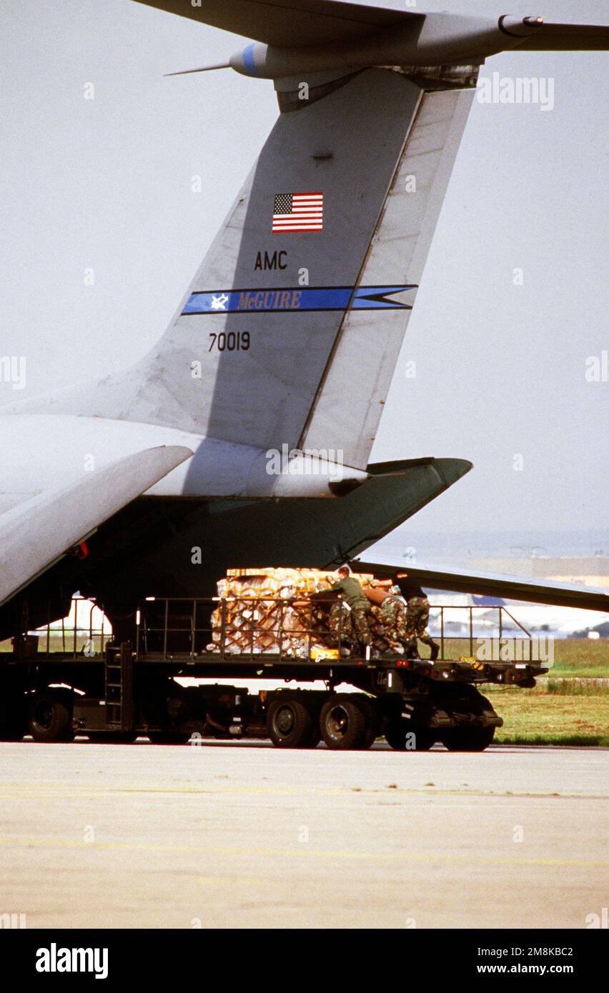 Members of the 626th Aerial Port Squadron (APS), push a pallet of cargo ...