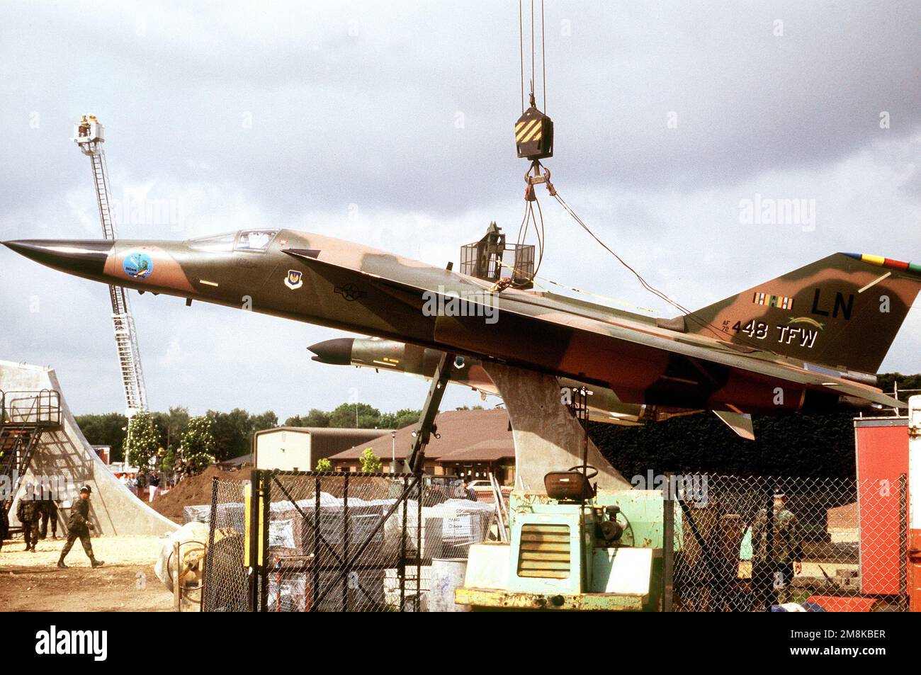 An F-111 Aardvark is lifted onto its permanent display stand in the ...