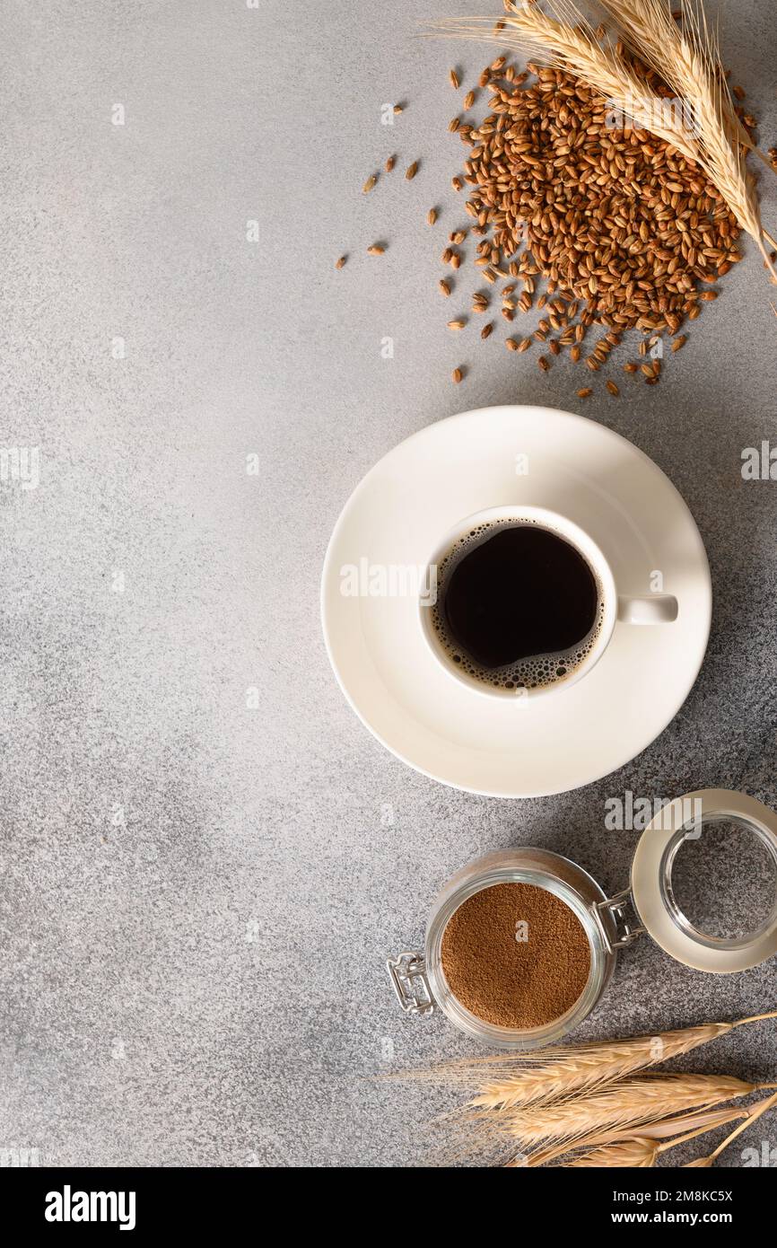 Barley coffee in white cup, beans and ears of barley on gray background ...