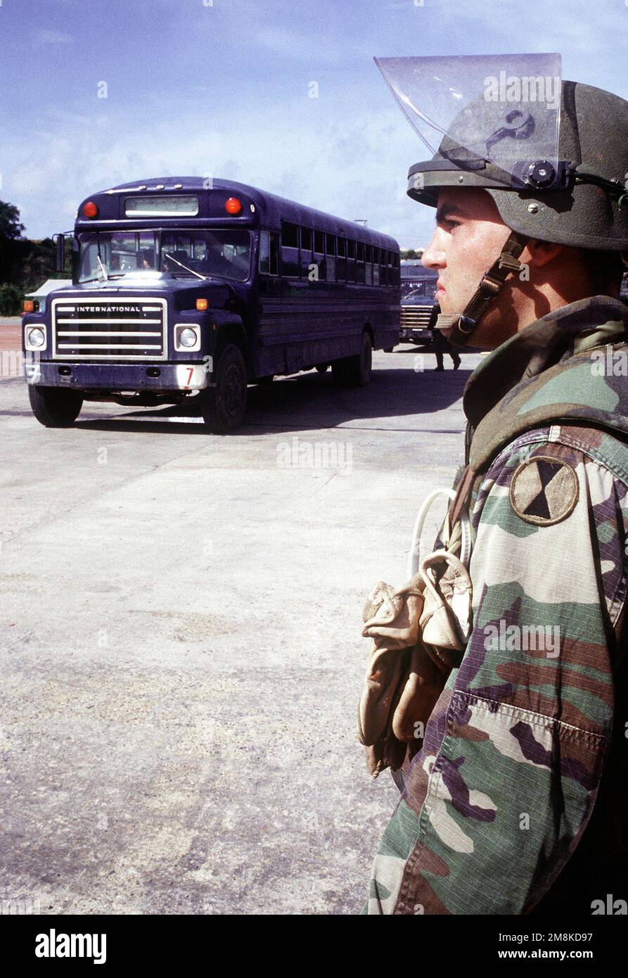 A US Army military policeman stands in full gear as a bus of Cuban ...