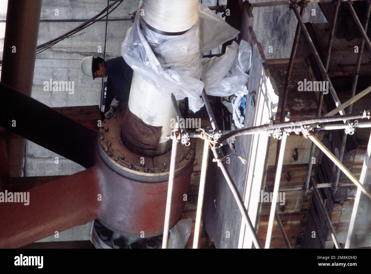 Cesar Desca tightens bolts on the strut bearing on the port shaft of ...