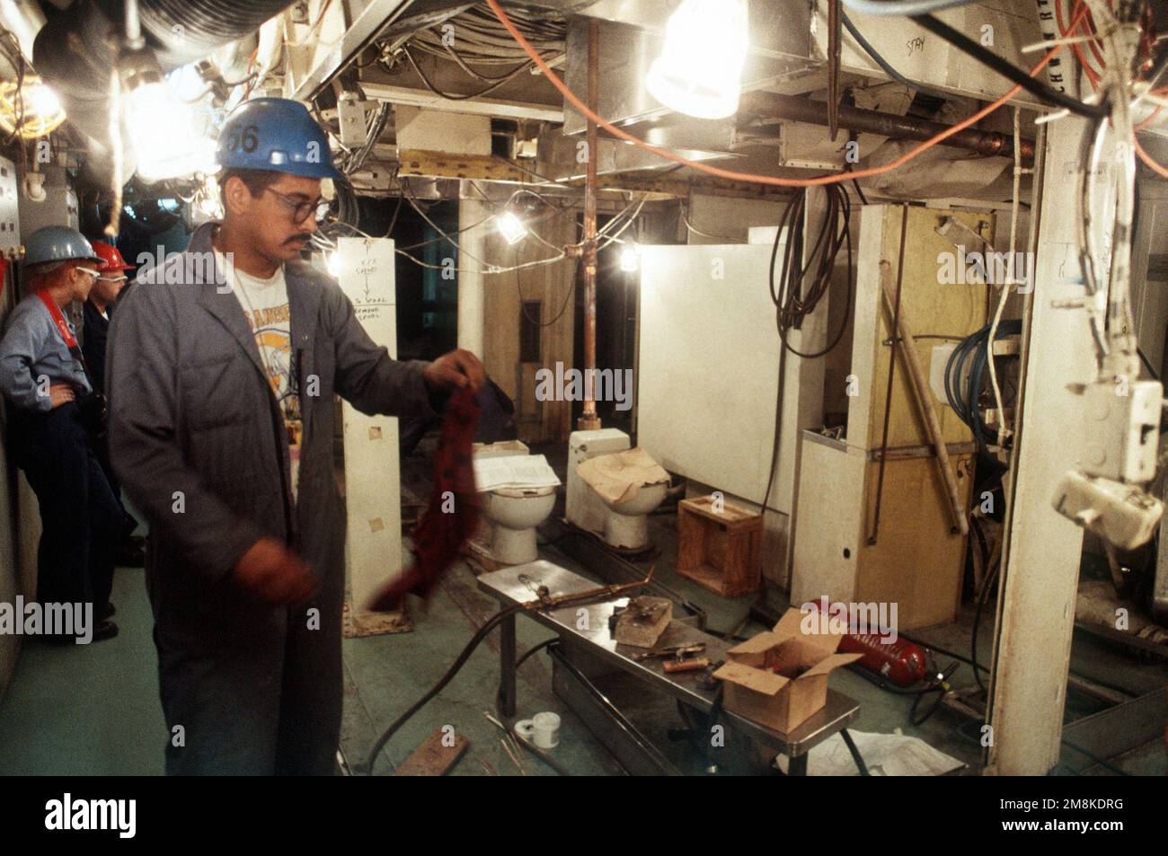 A shipyard worker, Armando Euceda, works on the plumbing in what will be the new female head on ...