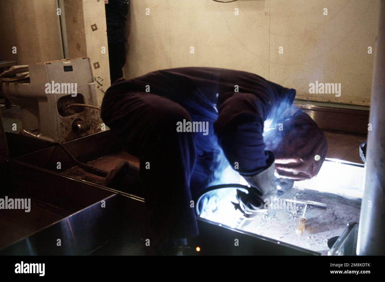 Steve Nim, a Long Beach Naval shipyard worker, welds on the deck in the ...