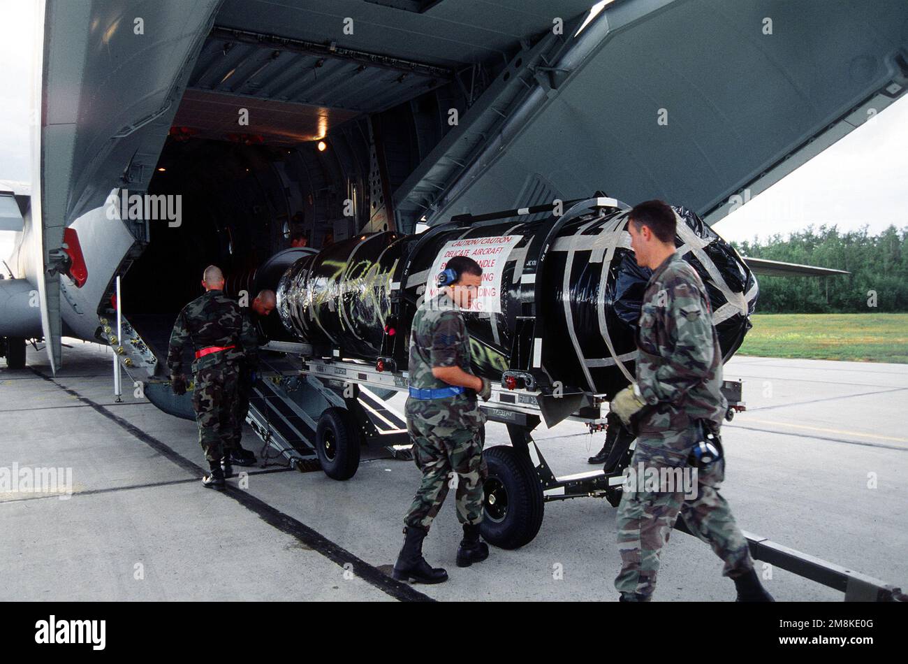 An aircraft engine on its cart and packed for shipment, is rolled unto ...